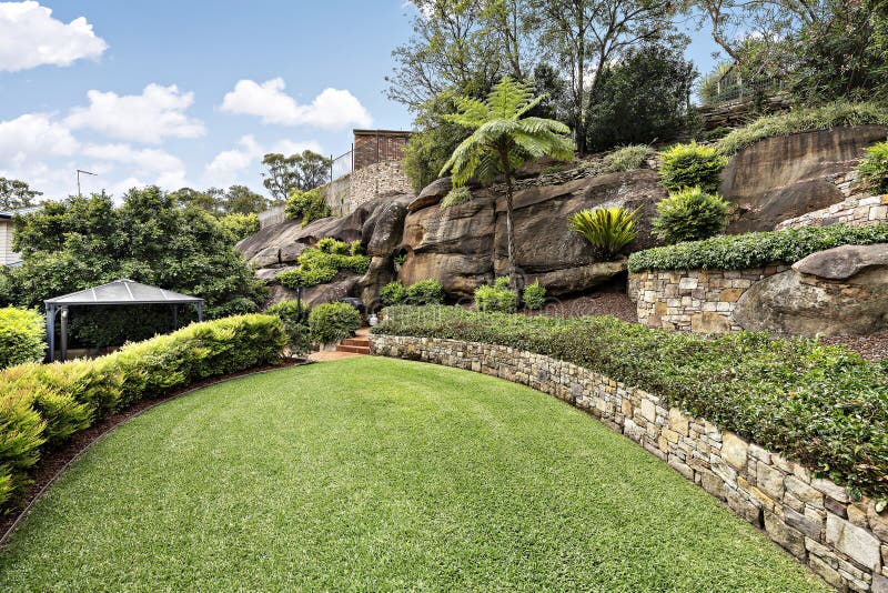 Backyard with Rocks on a Grassy Hillside Stock Image - Image of ...