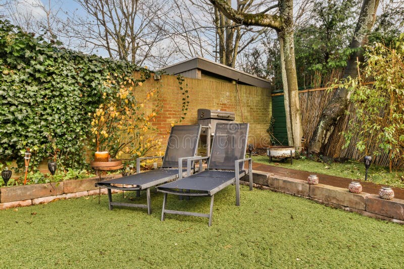 A Backyard with Two Chairs and a Grill Stock Image - Image of chairs ...