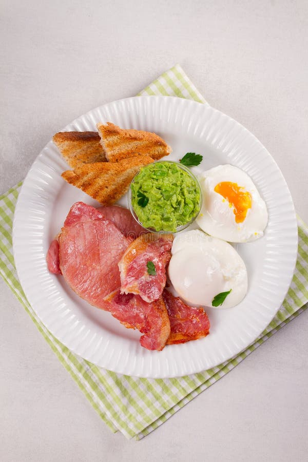 Bacon, Poached Eggs, Mashed Peas and Toasts on White Plate. Grilled ...