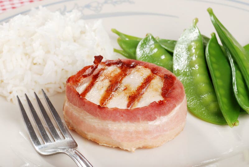 Bacon Wrapped Chicken with Rice and Snow Peas Stock Photo - Image of ...