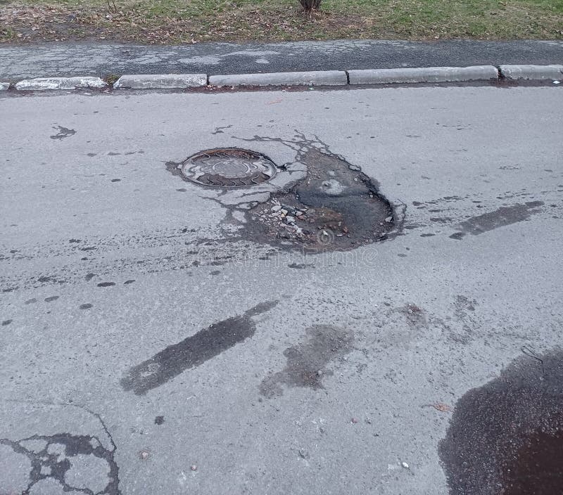A Hole in the Asphalt Next To a Sewage Manhole Stock Photo - Image of ...