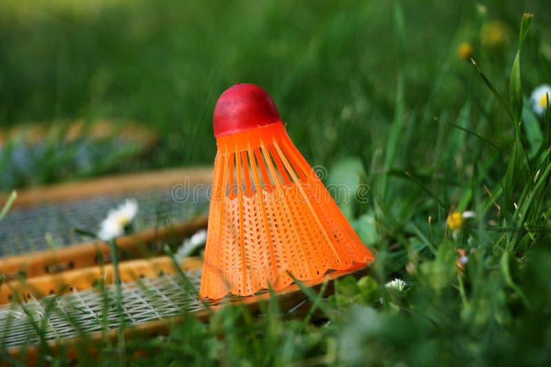 Badminton Rackets with Orange Shuttlecock on Green Grass Stock Image ...