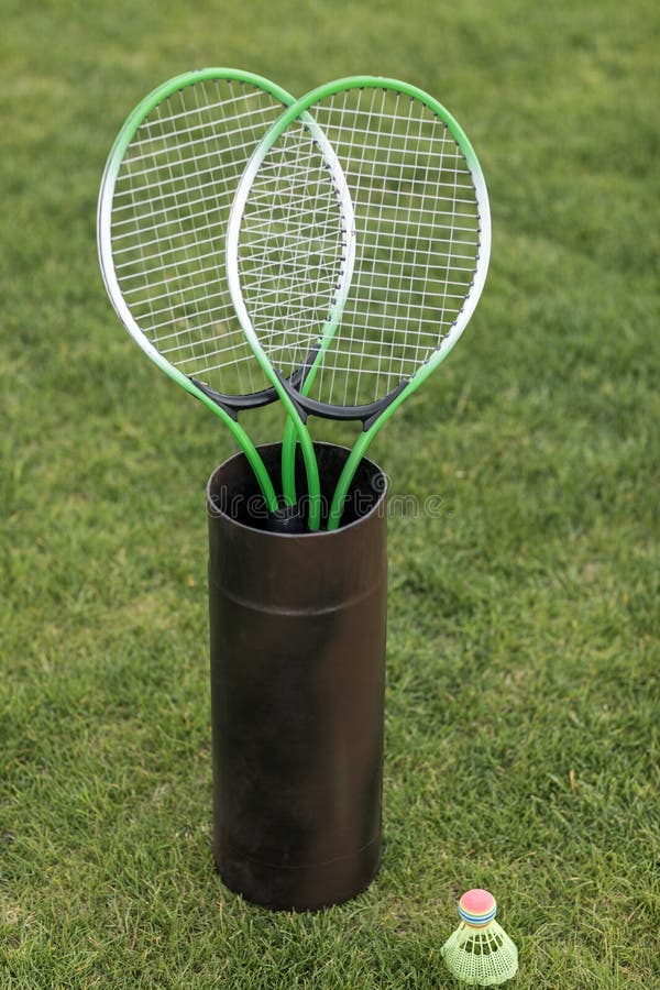 Badminton Racquets in Container and Shuttlecock on Green Grass Stock ...