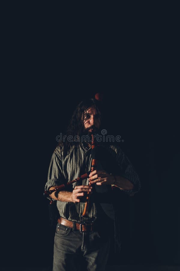 Bagpipe Player Playing His Instrument in an Auditorium with Stage ...