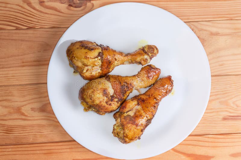 Baked Chicken Drumsticks on Dish on Rustic Table, Top View Stock Photo ...