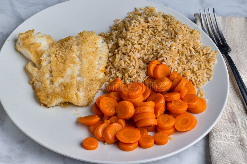Baked Cod Served with Brown Rice and a Side of Carrots Stock Photo ...