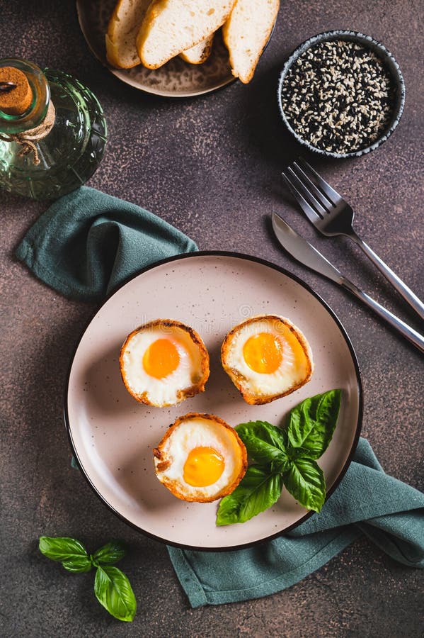 Baked Egg and Bacon Rolls with Basil on a Plate on a Table Top and ...