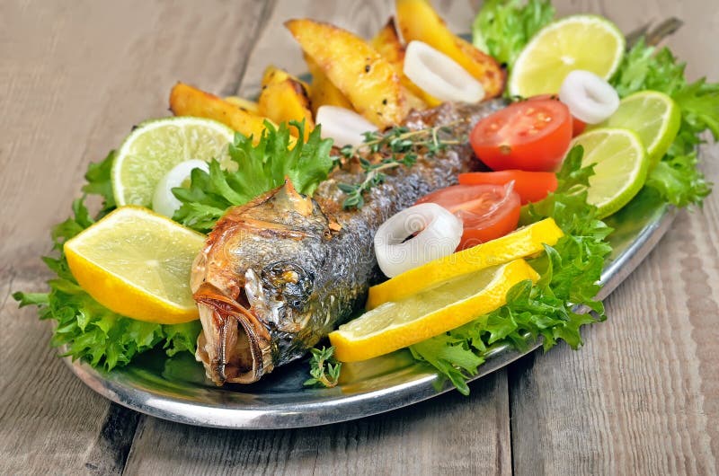 Baked fish on rustic table stock photo. Image of barbecue - 52414906