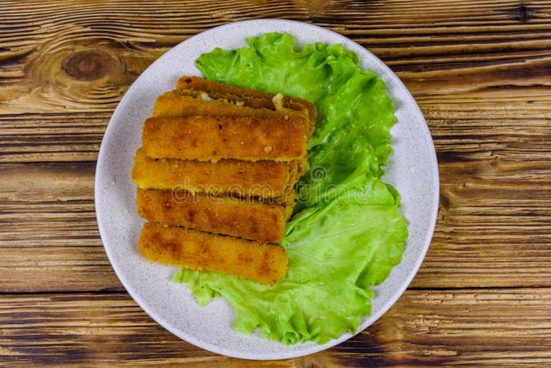 Baked Fish Sticks and Lettuce Leaves in a Plate. Top View Stock Photo ...