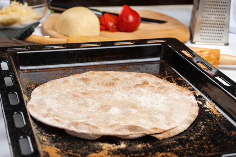 Baked Flatbread or Pizza Base on a Black Baking Sheet in the Kitchen ...