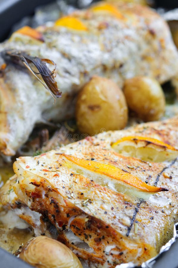 Baked Haddock with Lemon Slices and Small Potatoes Stock Photo - Image ...