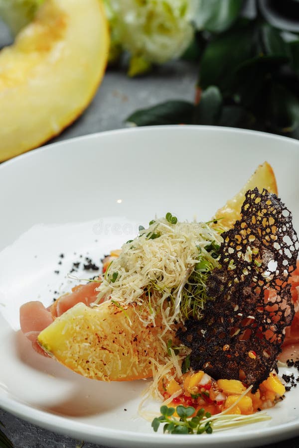 Baked Melon with Parmesan and Jamon on a White Plate Stock Image ...