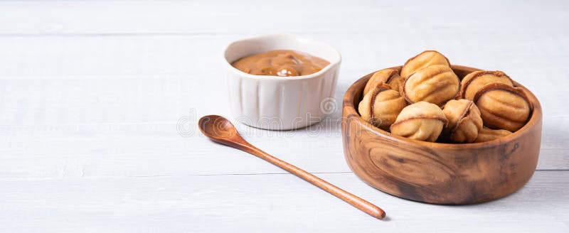 Baked Nuts with Boiled Milk in a Wooden Bowl and Caramel on a White ...