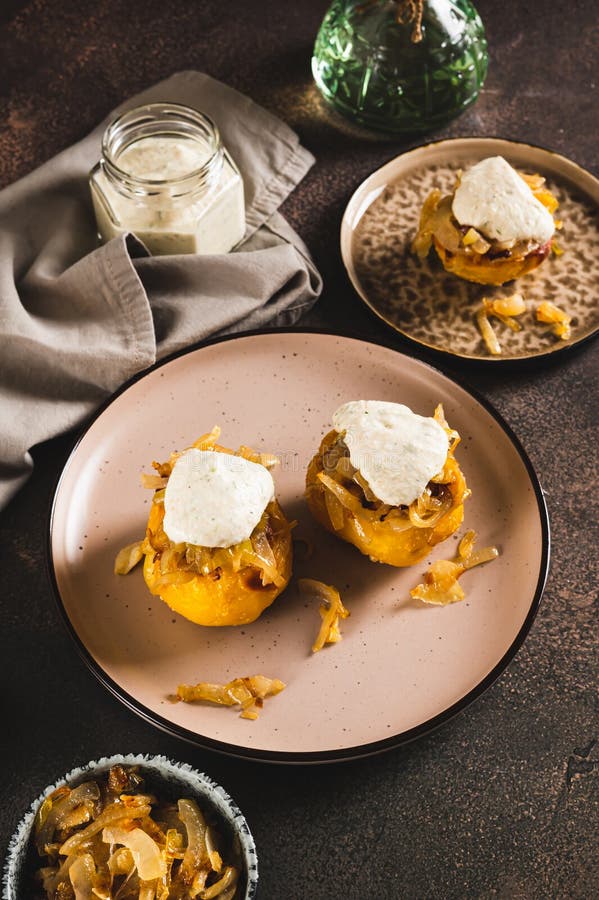 Baked Potatoes with Caramelized Onions and Hot Sauce on a Plate on the ...