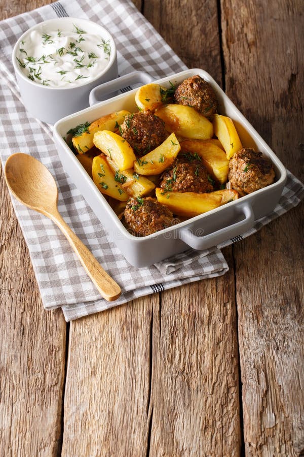 Baked potatoes with meatballs in a dish close up. vertical - Stock ...