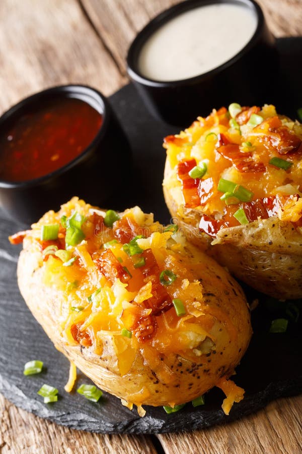 Baked Potatoes Stuffed with Cheddar Cheese and Bacon Closeup. Vertical ...