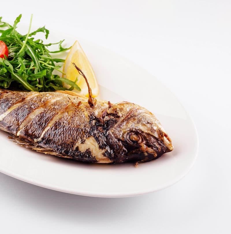Baked Sea Bream Fish with Arugula Salad and Tomatoes Stock Image ...