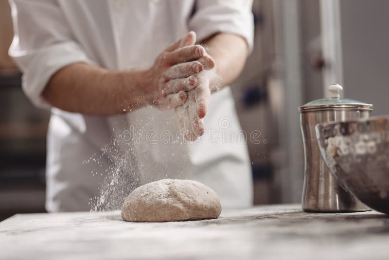 Baker Adds Flour To Dough on the Table in the Bakery Stock Image ...