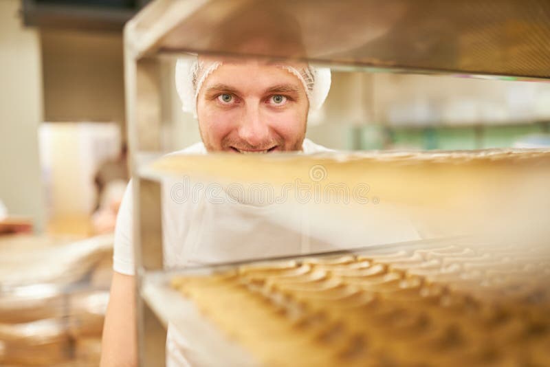 Baker Apprentice Stands Behind Shelf Trolley with Baked Goods Stock ...