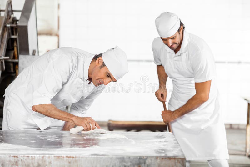 Baker Cleaning Table while Colleague Using Mop Stock Photo - Image of ...