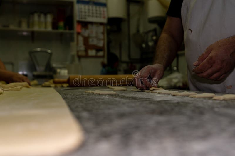 Baker Cutting the Dough into Triangles for Making Croissants in a ...