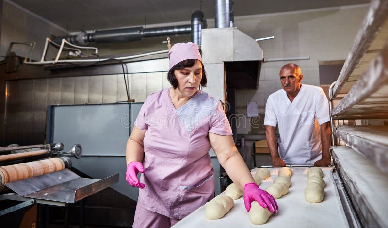 The Baker Forms the Dough for Baking Bread and Put it into Oven-tray at ...