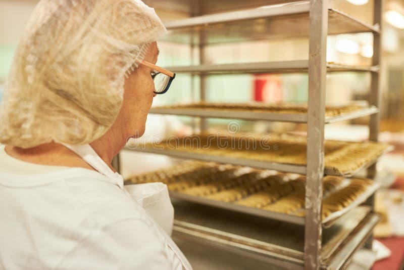 Baker Looks at a Tray Trolley with Baked Goods Stock Photo - Image of ...