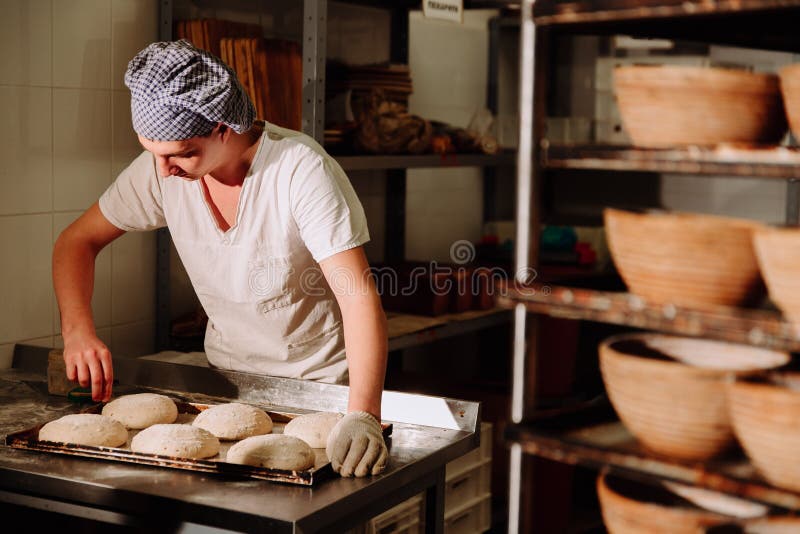A Baker Makes Manual Incisions on the Dough for the Bread. the ...