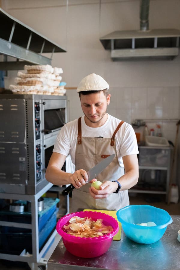 A Baker is Peeling Onions in a Small Artisan Bakery. Stock Photo ...