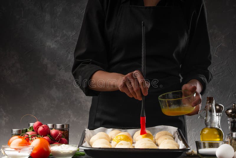 A Baker Prepares Buns for Baking, Spreading with an Egg, a Bakery and ...
