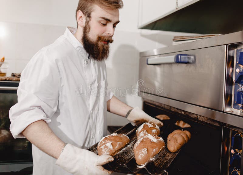 Baker Pulls Out of the Oven a Baking Sheet the Baking Tray with Newly ...