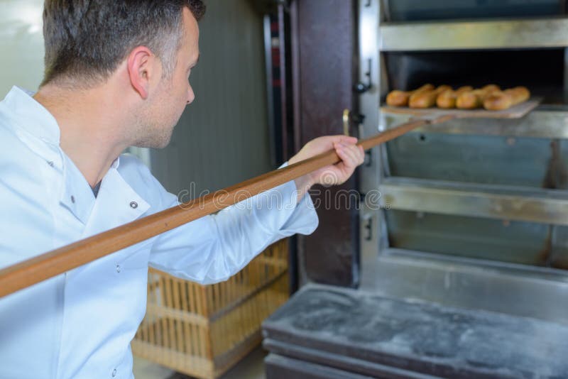 Baker Removing Bread from Oven Stock Photo - Image of bread, cooking ...