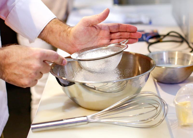 Baker Sieving Flour Into A Bowl In The Kitchen Of The Bakery Stock ...