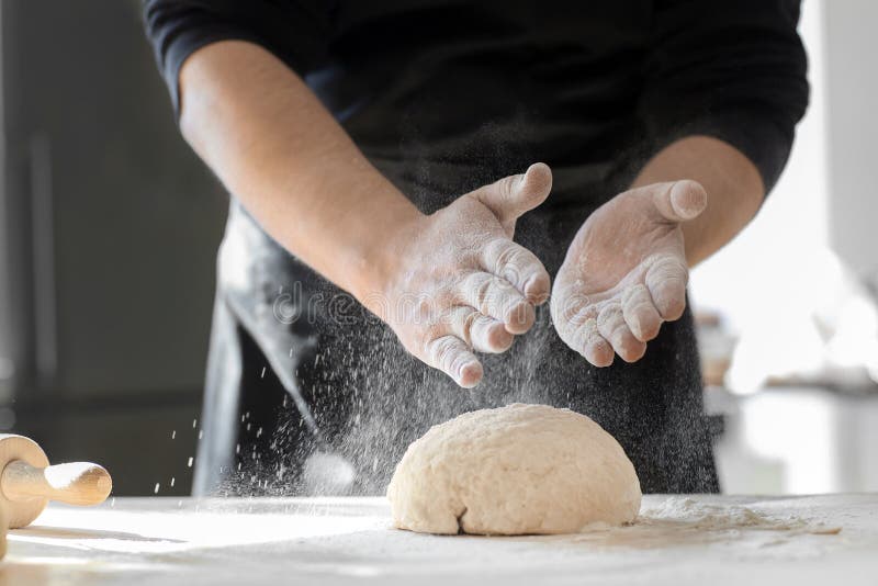 Baker Sprinkling Flour Over Dough on Kitchen Table Stock Image - Image ...