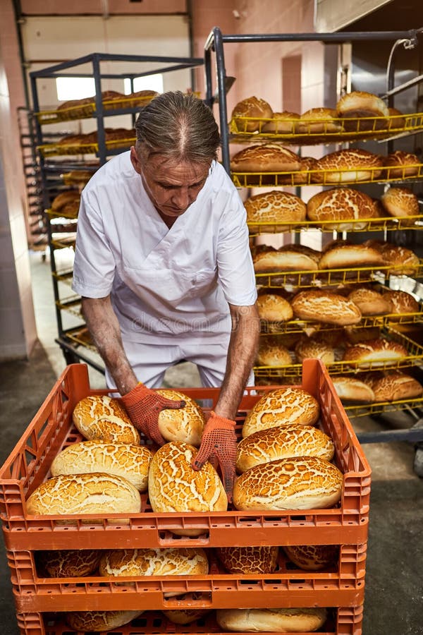 Baker Stacks Fresh Hot Bread on a Tray Against the Backdrop of Pastry ...
