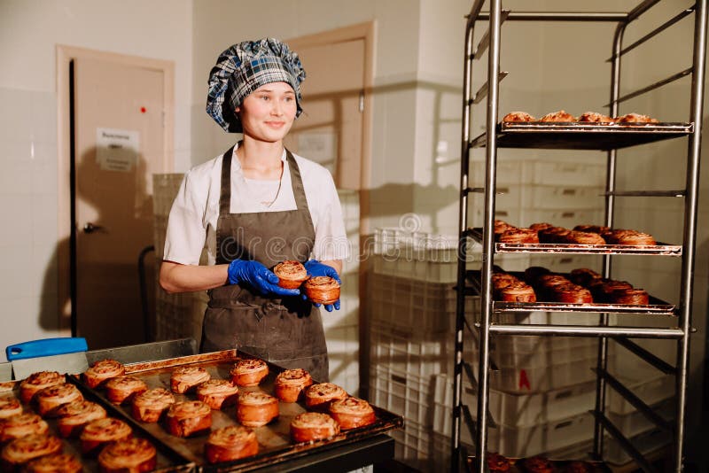 Baker Standing in His Bakery in the Morning and is Baking Bread or Buns ...