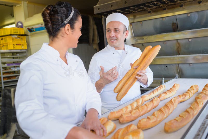 Baker Talking To Apprentice by Bread Oven Stock Photo - Image of ...
