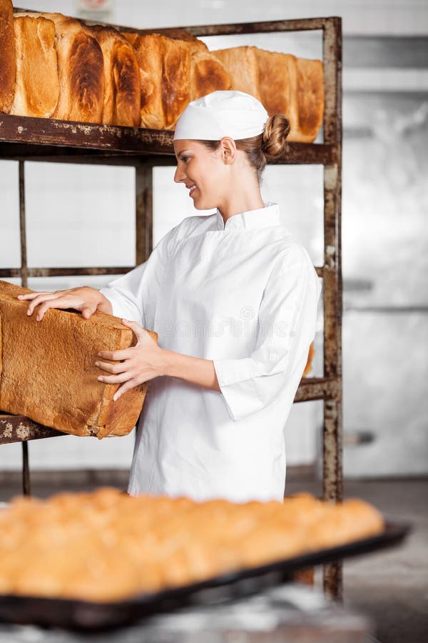 Baker in Uniform Removing Bread Loaf from Rack Stock Photo - Image of ...