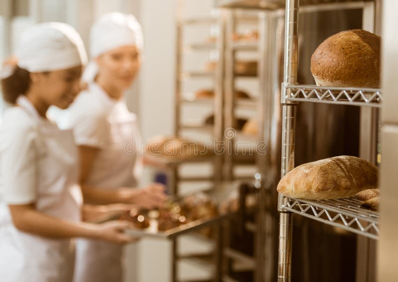 Bakers Working at Baking Manufacture with Fresh Loaves of Bread Lying ...