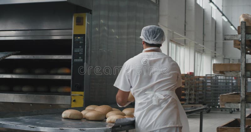 Bakery Industry Workers Unloaded the Cooked Bread from the Oven Machine ...