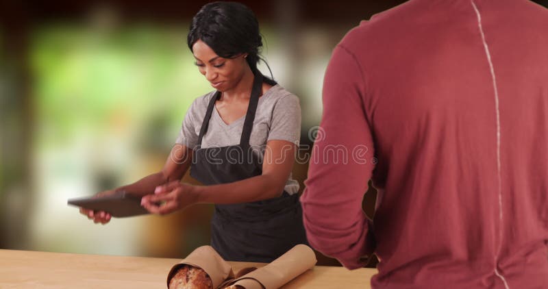 Bakery Owner Selling Bread To Customer Using New Tablet Computer ...