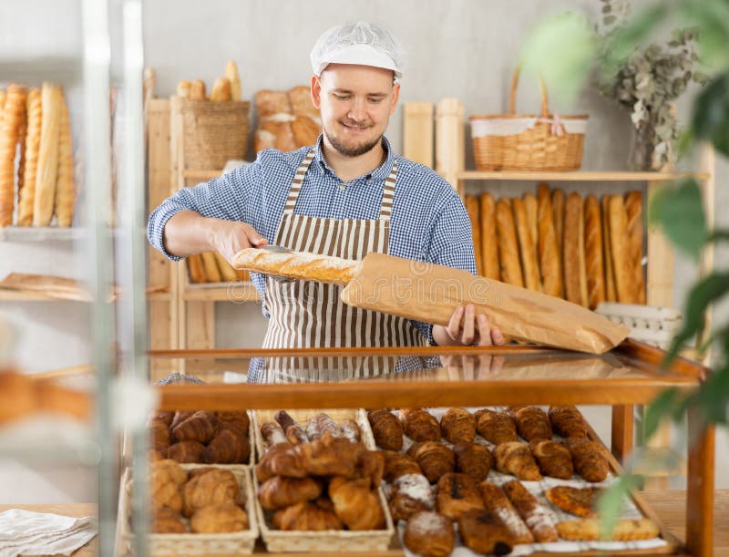 Bakery Worker Places Fresh Baguette in Paper Bag Stock Photo - Image of ...