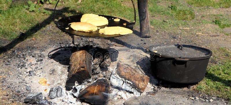 Baking Bread on a Griddle Over Fire Outdoors in 1800`s America Stock ...