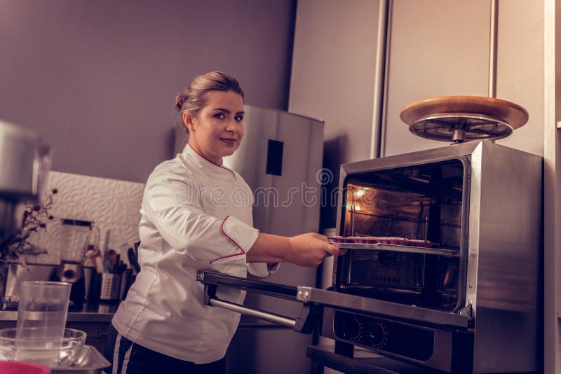 Delighted Female Pastry Chef Using the Oven Stock Photo - Image of ...