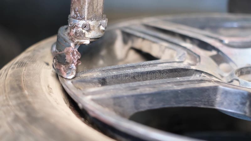 Balancing and Repair of Car Wheels. a Car Mechanic Works in a Workshop ...