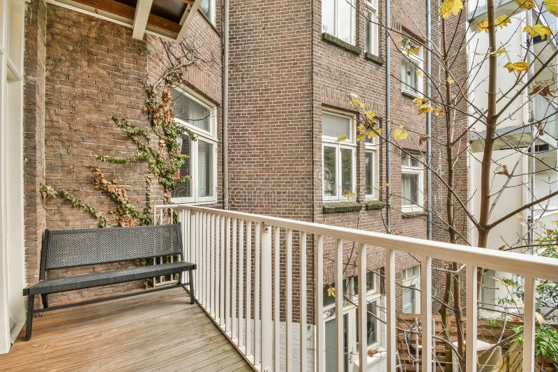 A Balcony with a Bench and a Brick Building Stock Photo - Image of town ...