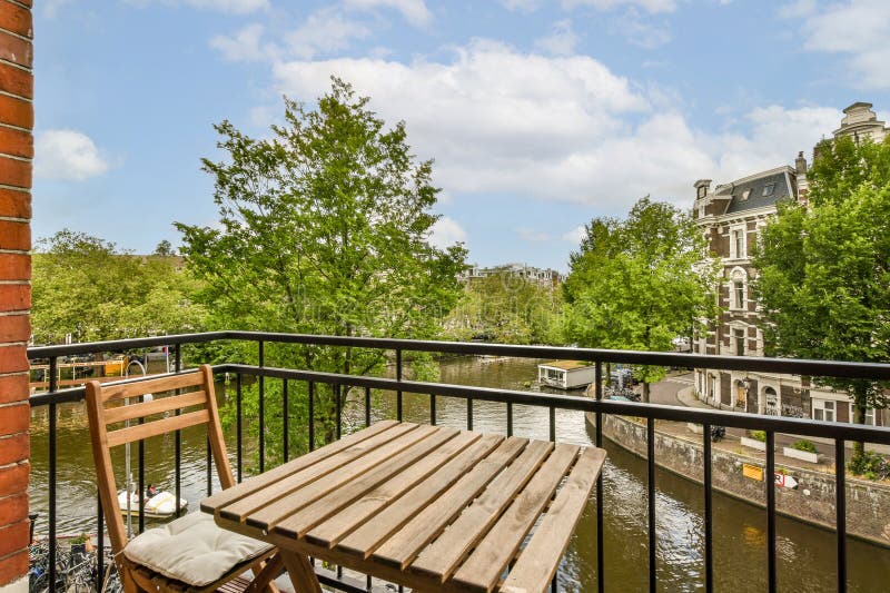 A Balcony with a Table and Chairs Overlooking a River Stock Photo ...