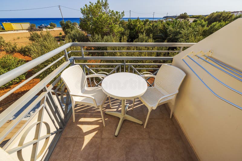 Balcony with White Plastic Table and Chairs, Overlooking Greenery and ...