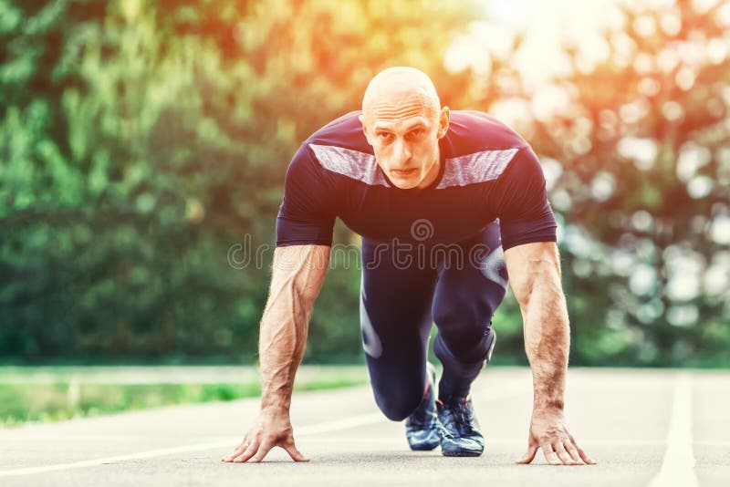Bald Athletic Man in Running Start Position and Looking into the ...