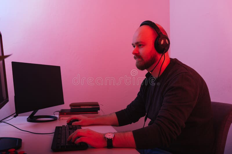 Bald Bearded Man Wearing Headset is Sitting and Working at the Computer ...